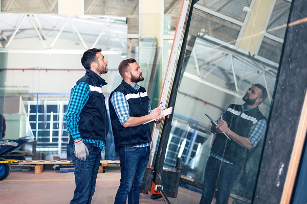 Workers handling glass sheet in warehouse - Glass and Glazing Federation